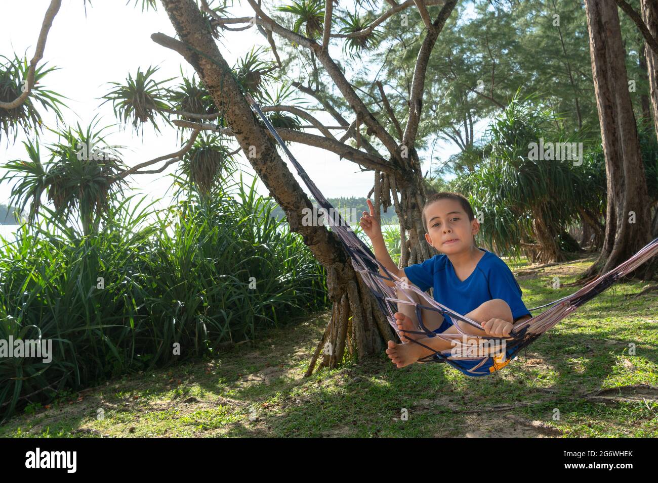 Kid sitting under shade tree hi-res stock photography and images - Alamy