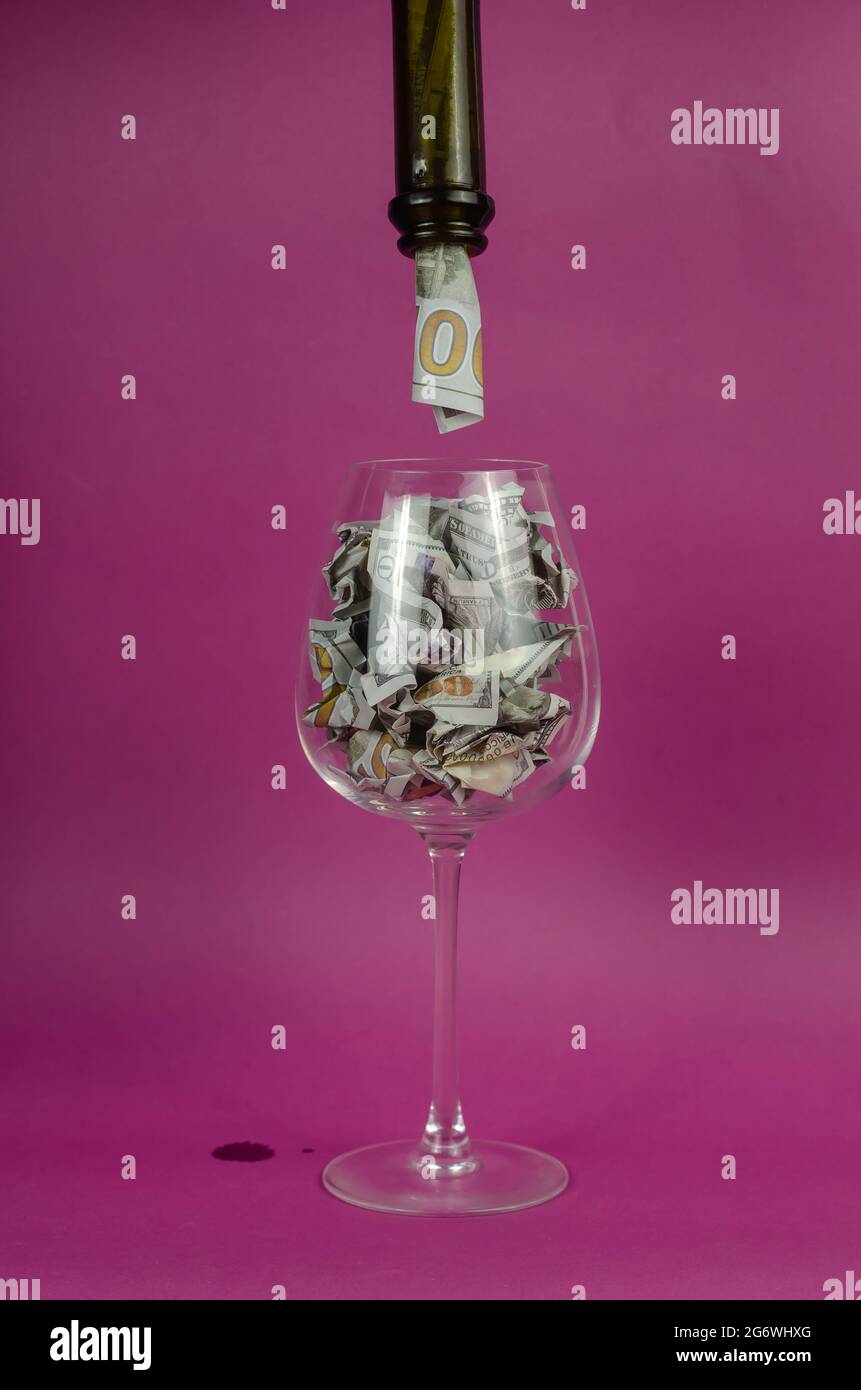 Wine glass is filled with money from bottle. WineGlass is full Crumpled ...