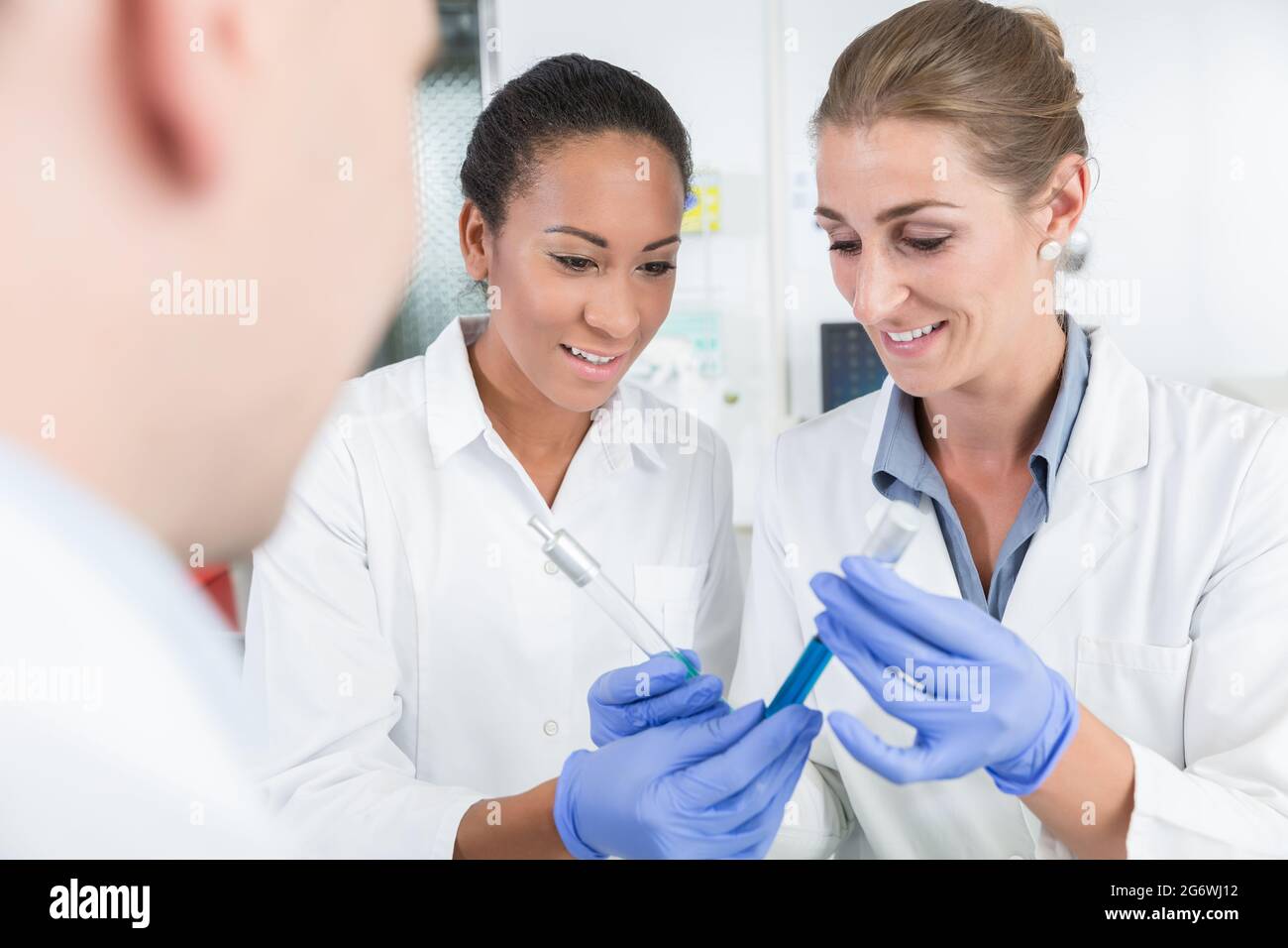 Team of researchers doing experiment in science lab Stock Photo - Alamy