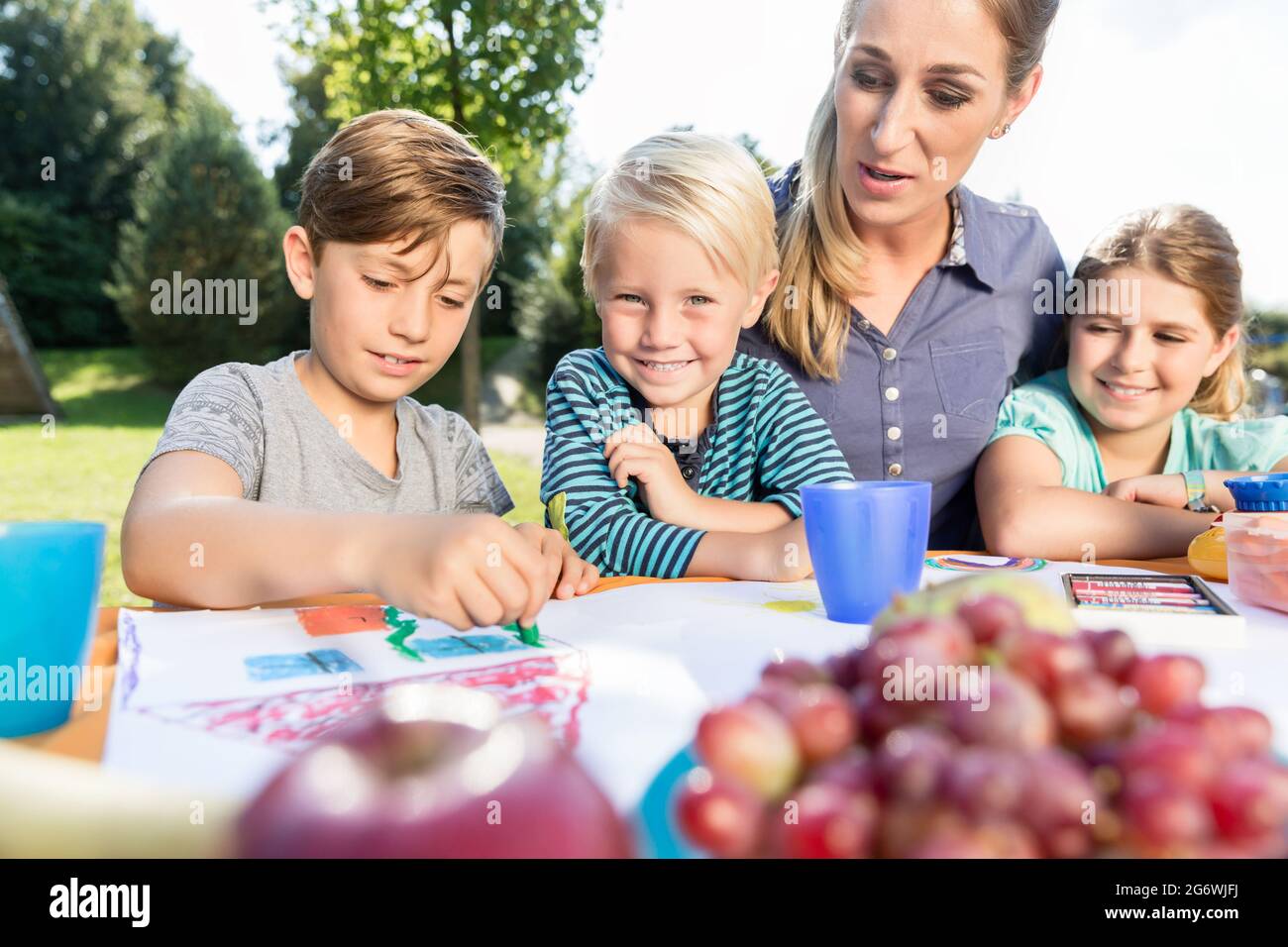 Mum painting pictures with their children and during lunch break Stock ...