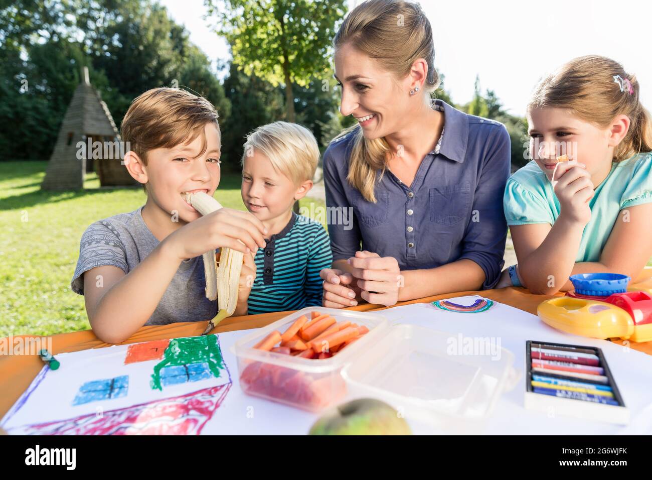 Family having breaktime at playground, kids painting and having healthy ...