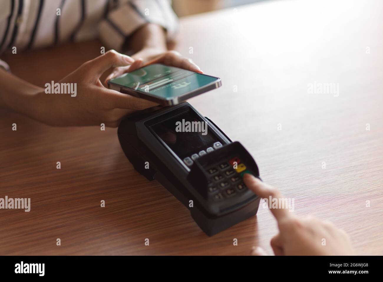 Payment by payment terminal on the wooden desk Stock Photo - Alamy