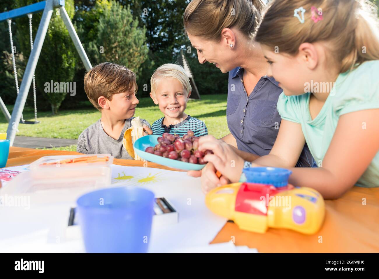 Family having breaktime at playground, kids painting and having healthy ...