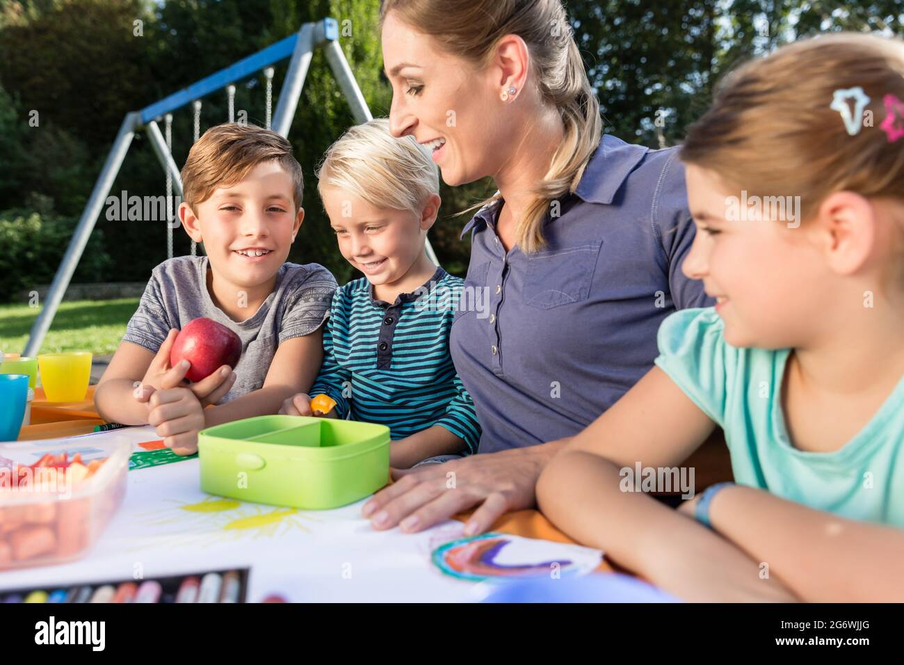 Family having breaktime at playground, kids painting and having healthy ...