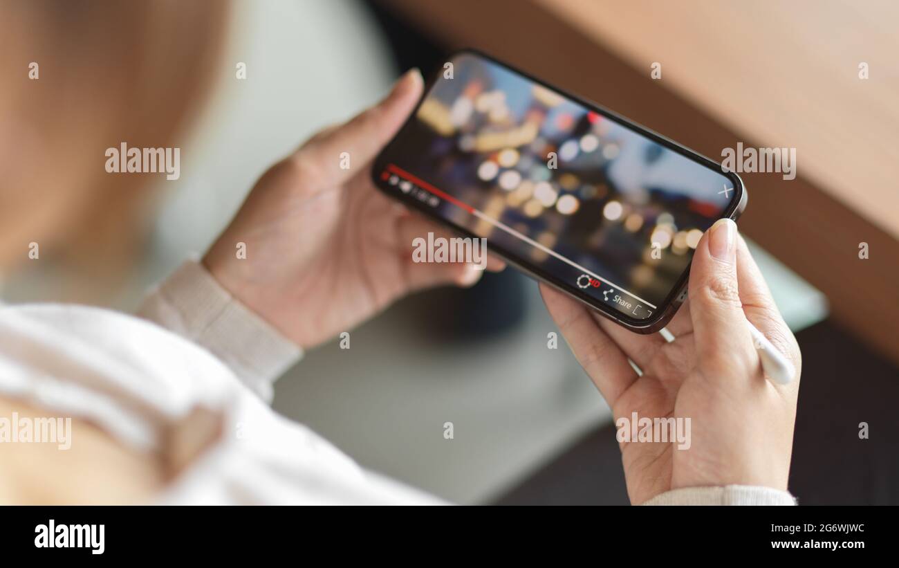 Closeup a girl watching video on mobile phone with two hand holding ...