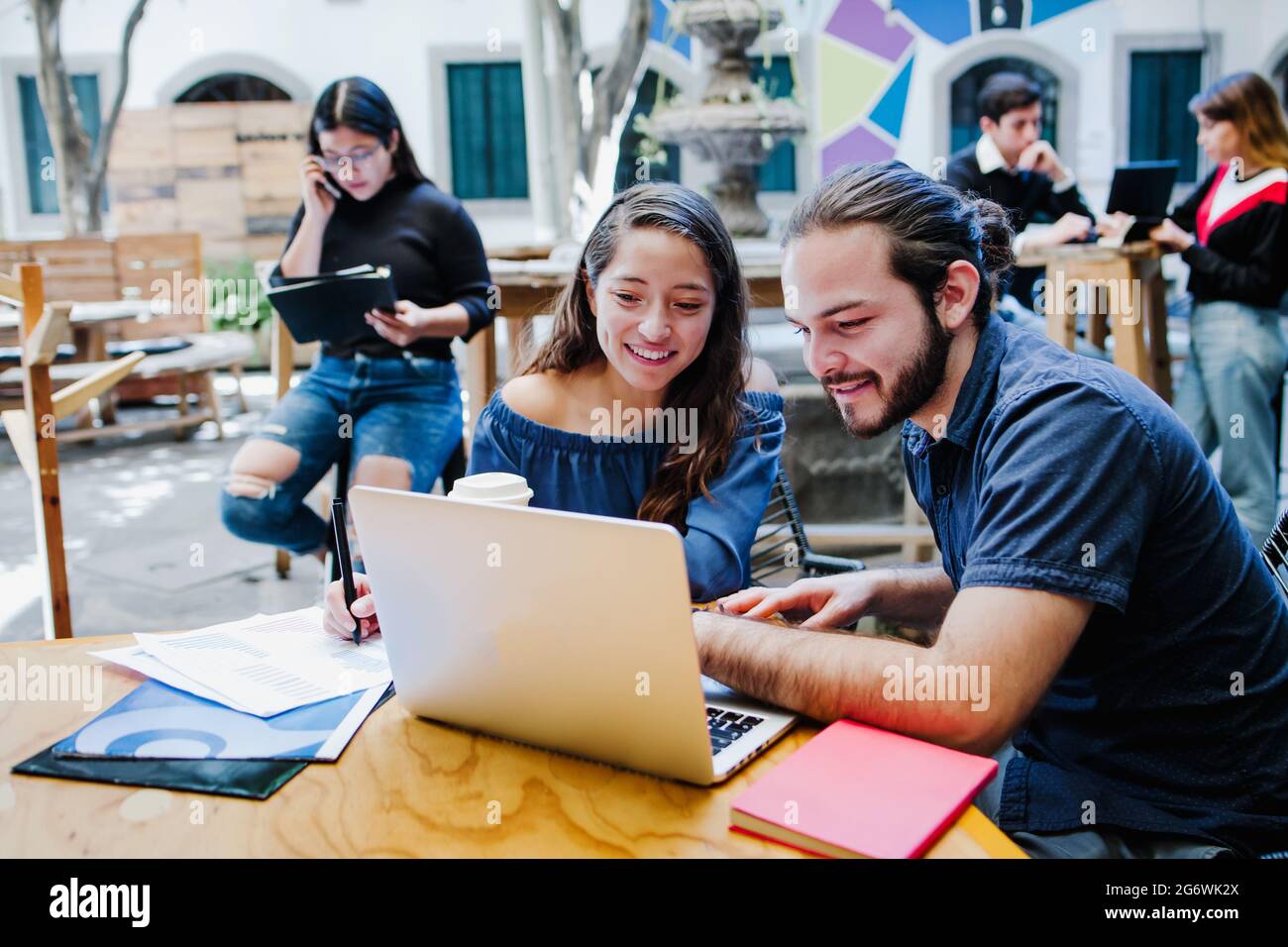 Group of young latin university students working on presentation for ...