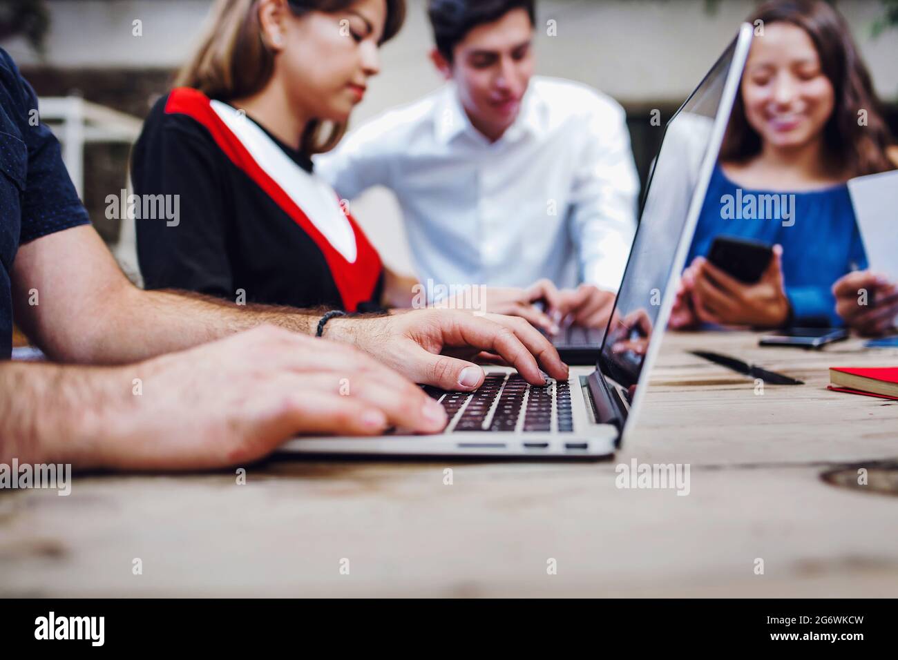 hands of man working on computer with latin people teamwork at ...