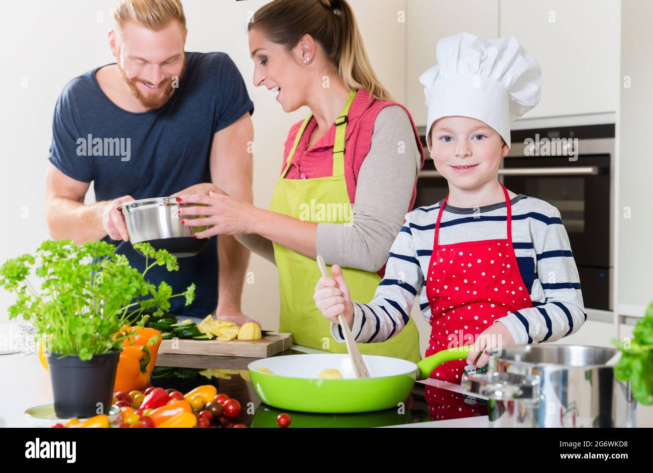 Happy family cooking together in kitchen Stock Photo - Alamy