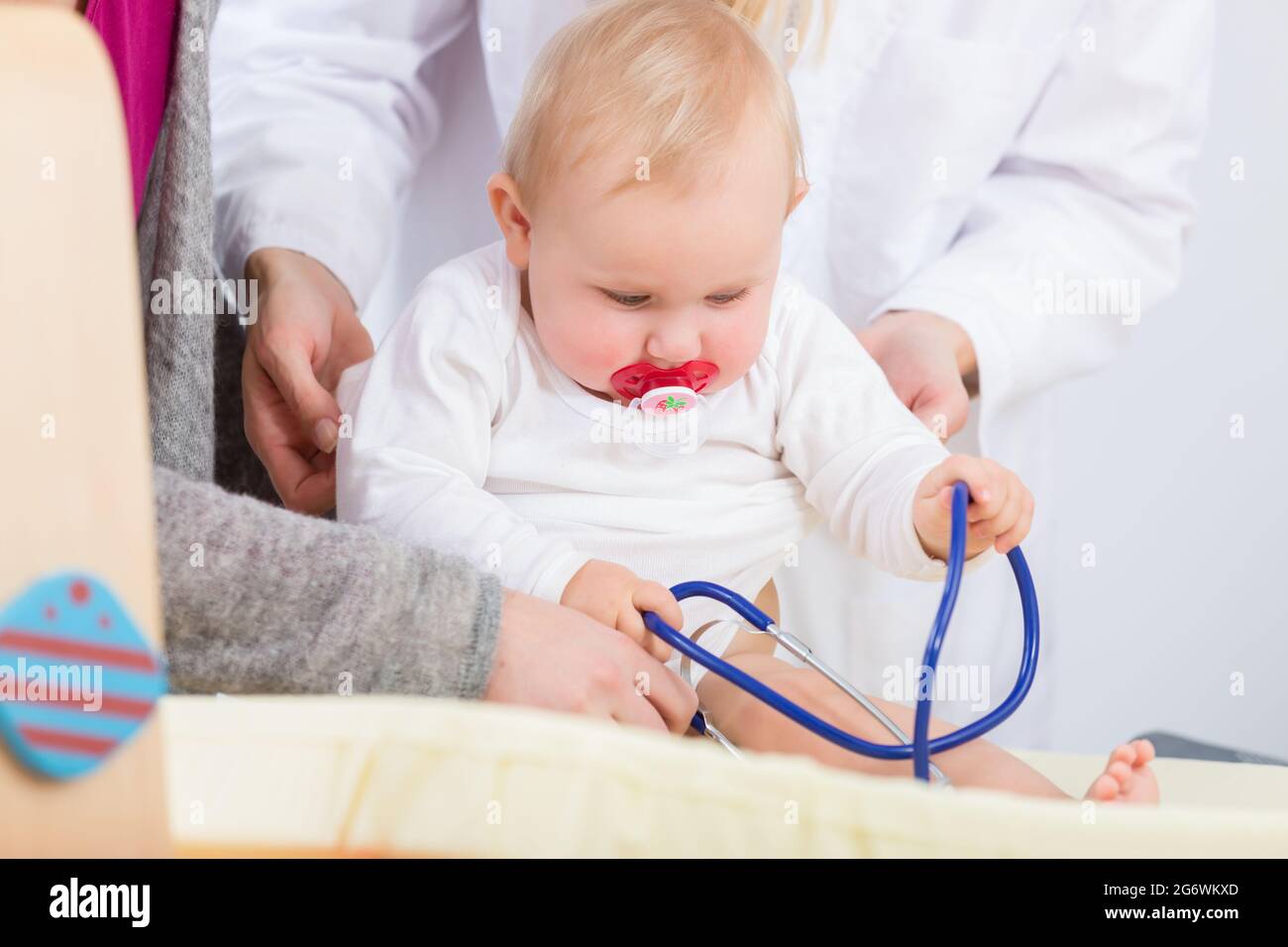 Cute and healthy baby girl playing with the stethoscope next to her ...