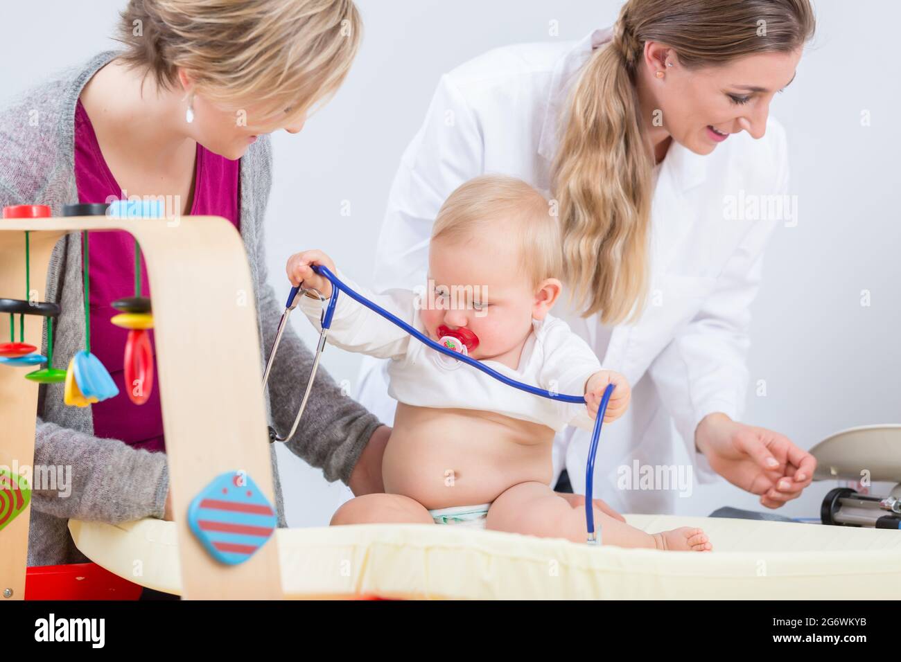 Cute and healthy baby girl playing with the stethoscope next to her ...