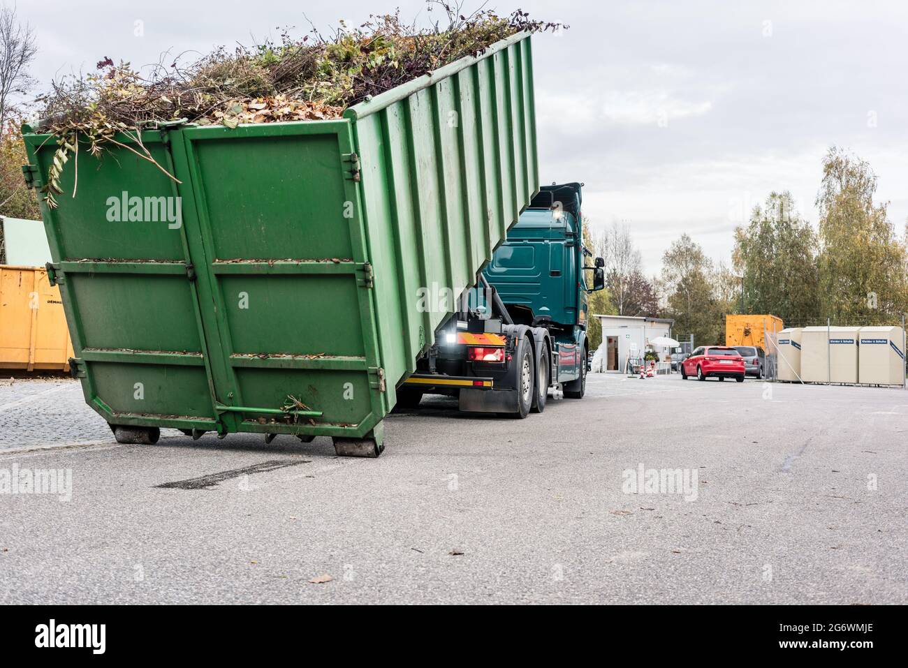 Truck loading container with waste green at recycling center to ...