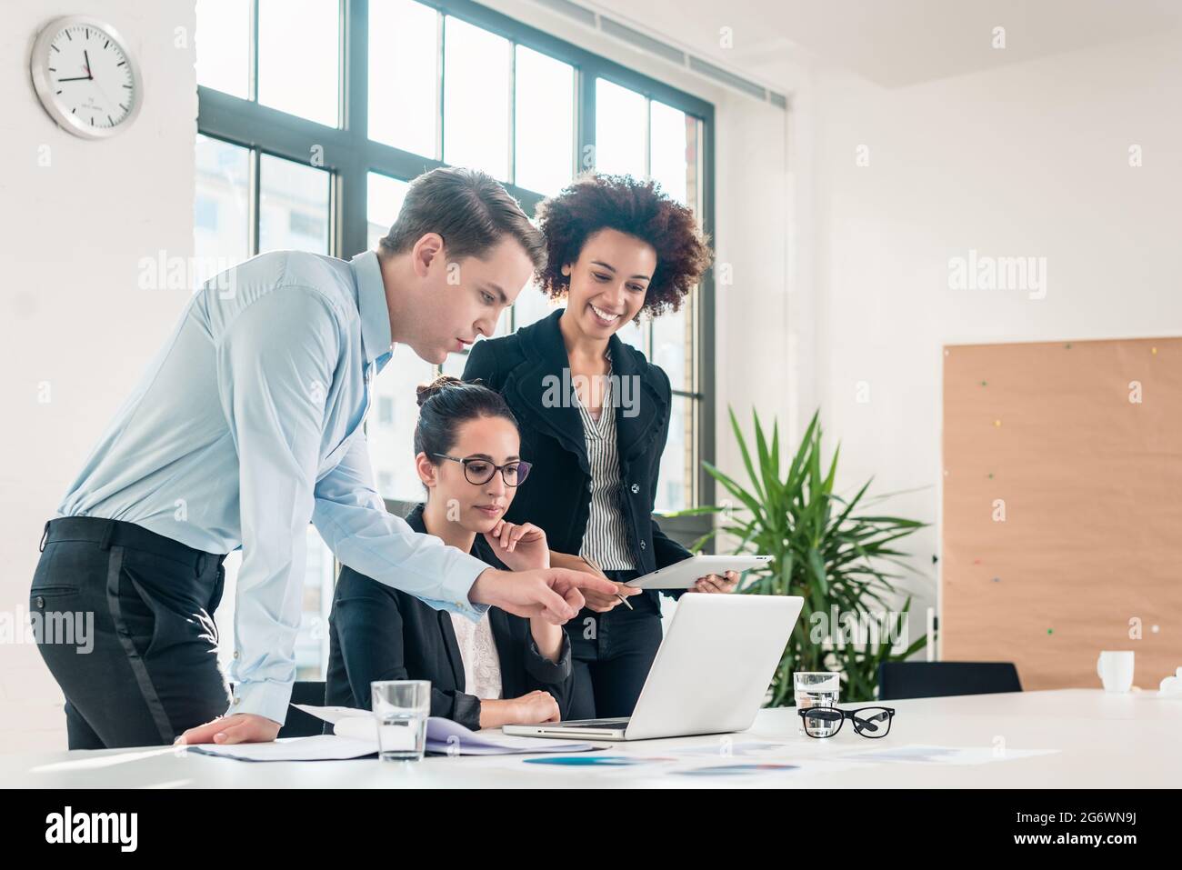 Three members of a young professional team working together in a modern ...