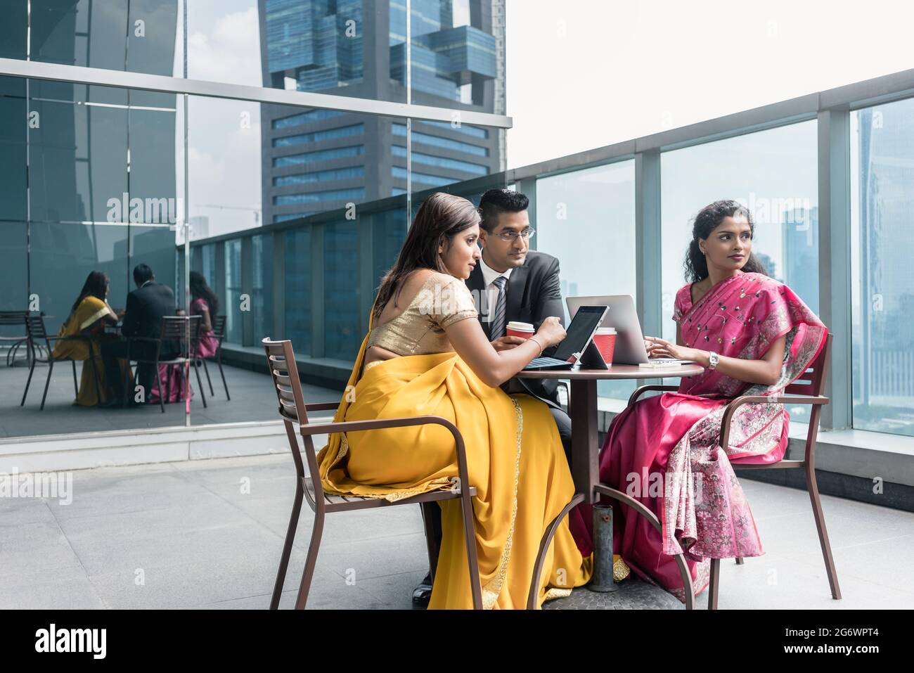 Three Indian business people with worried facial expression talking ...