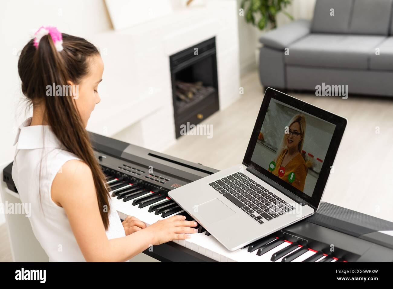 Little girl watching online lesson tutorial how to learn a synthesizer ...