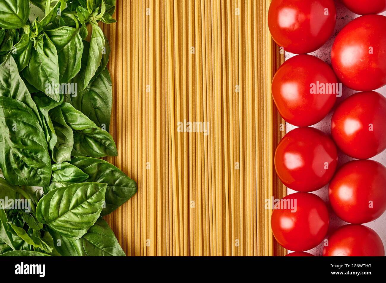 Spaghetti Italian pasta with basil leaves and tomatoes, arranged in the ...