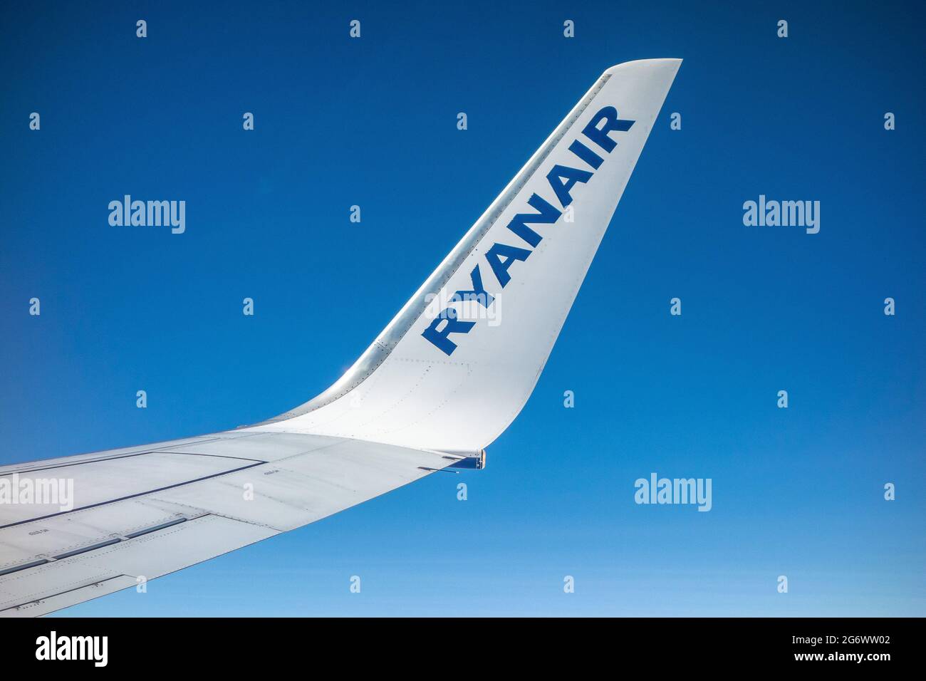 In the sky, Belgium, July 7, 2021. Wing of a Ryanair aircraft in a blue ...