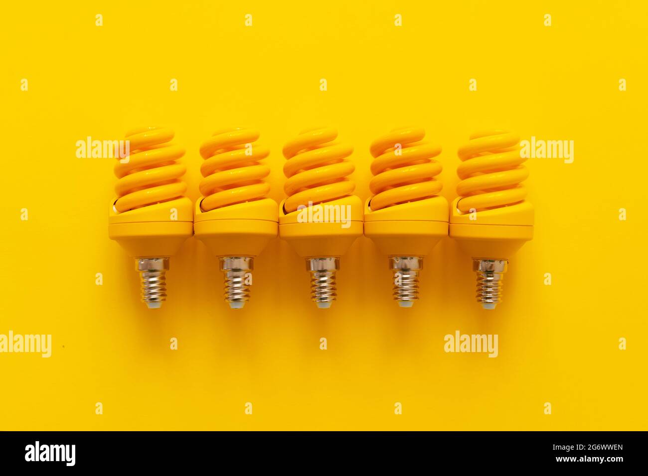 Light bulb on yellow paper background top view Stock Photo - Alamy
