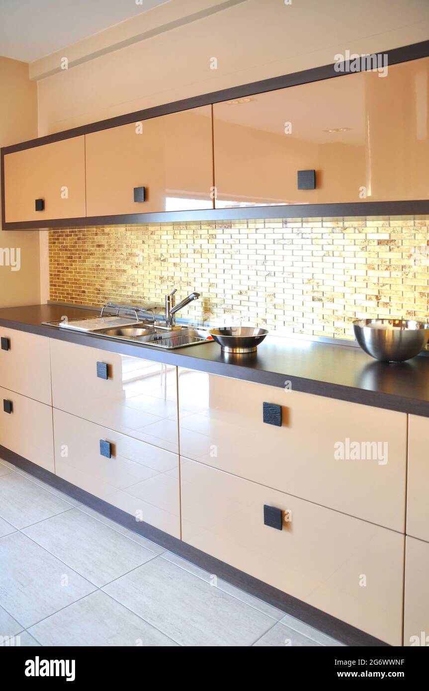 Interior of luxurious modern kitchen equipment, beige lacquer cabinets ...