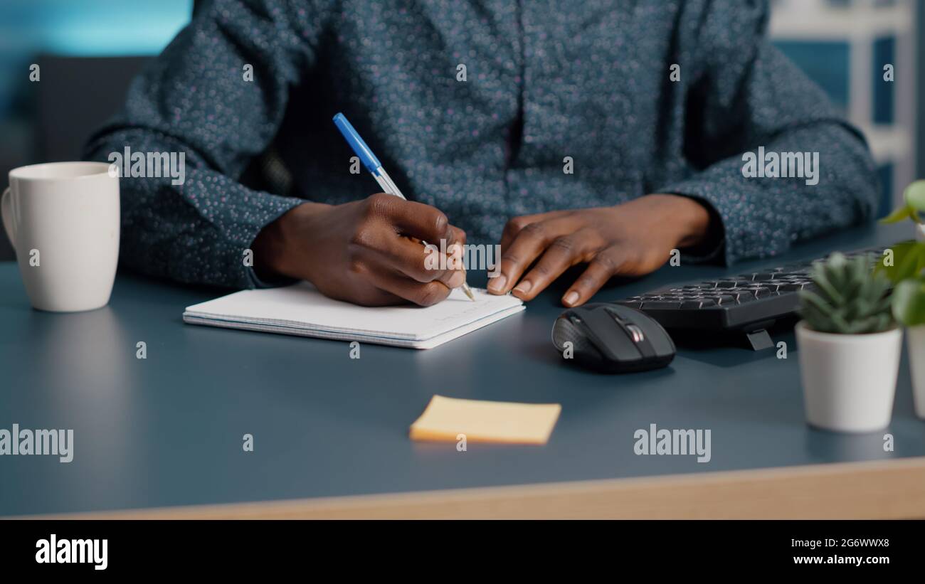 Closeup african american black man hands taking notes on notepad using ...