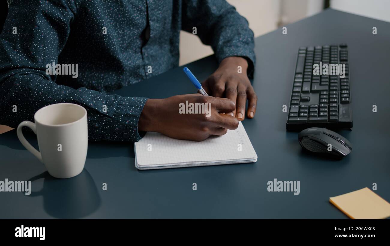 Close up of african american black person taking notes on notepad using ...