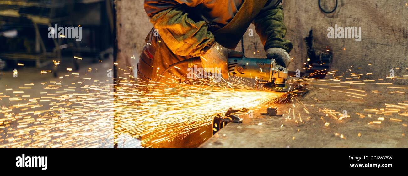 Locksmith in special clothes and goggles works in production. Metal ...