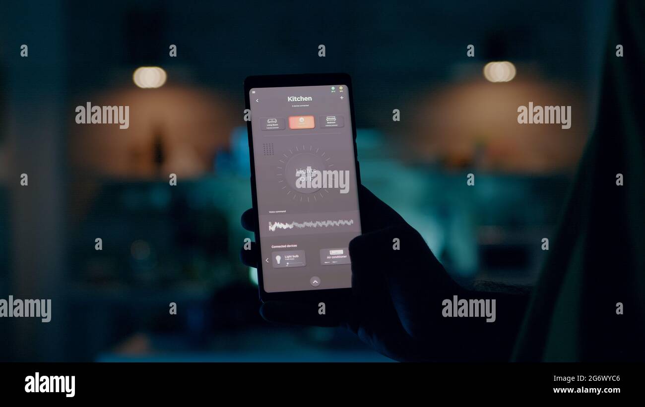 Person controlling house light using smart home application touching ...