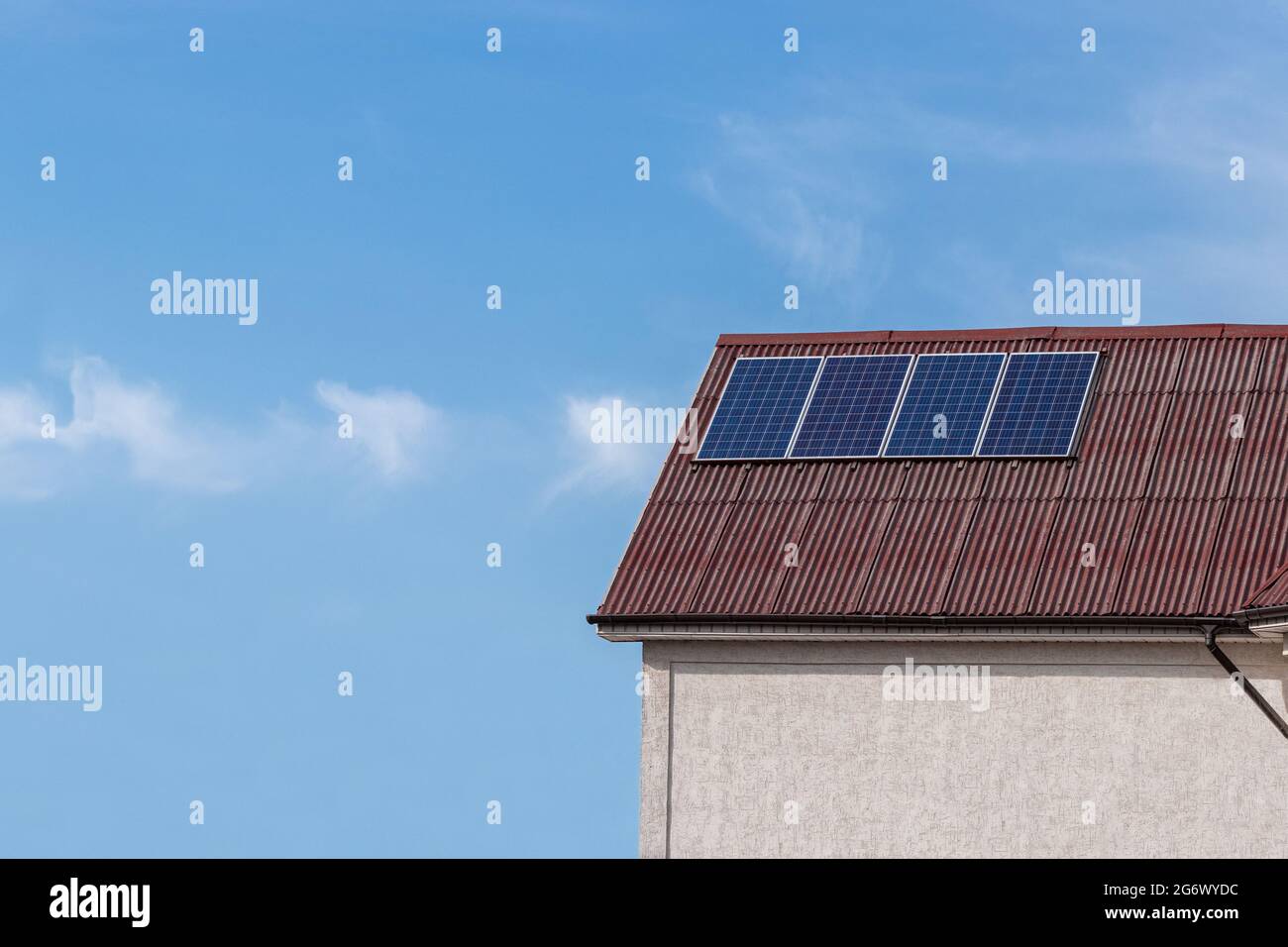 Four solar panels are installed on the roof slope of the house. The ...