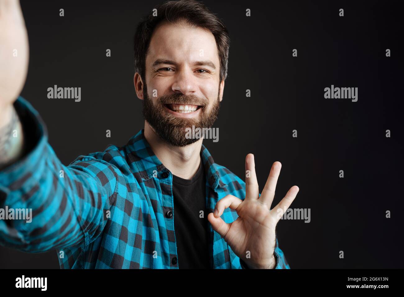 Bearded smiling man showing ok sign while taking selfie photo isolated ...