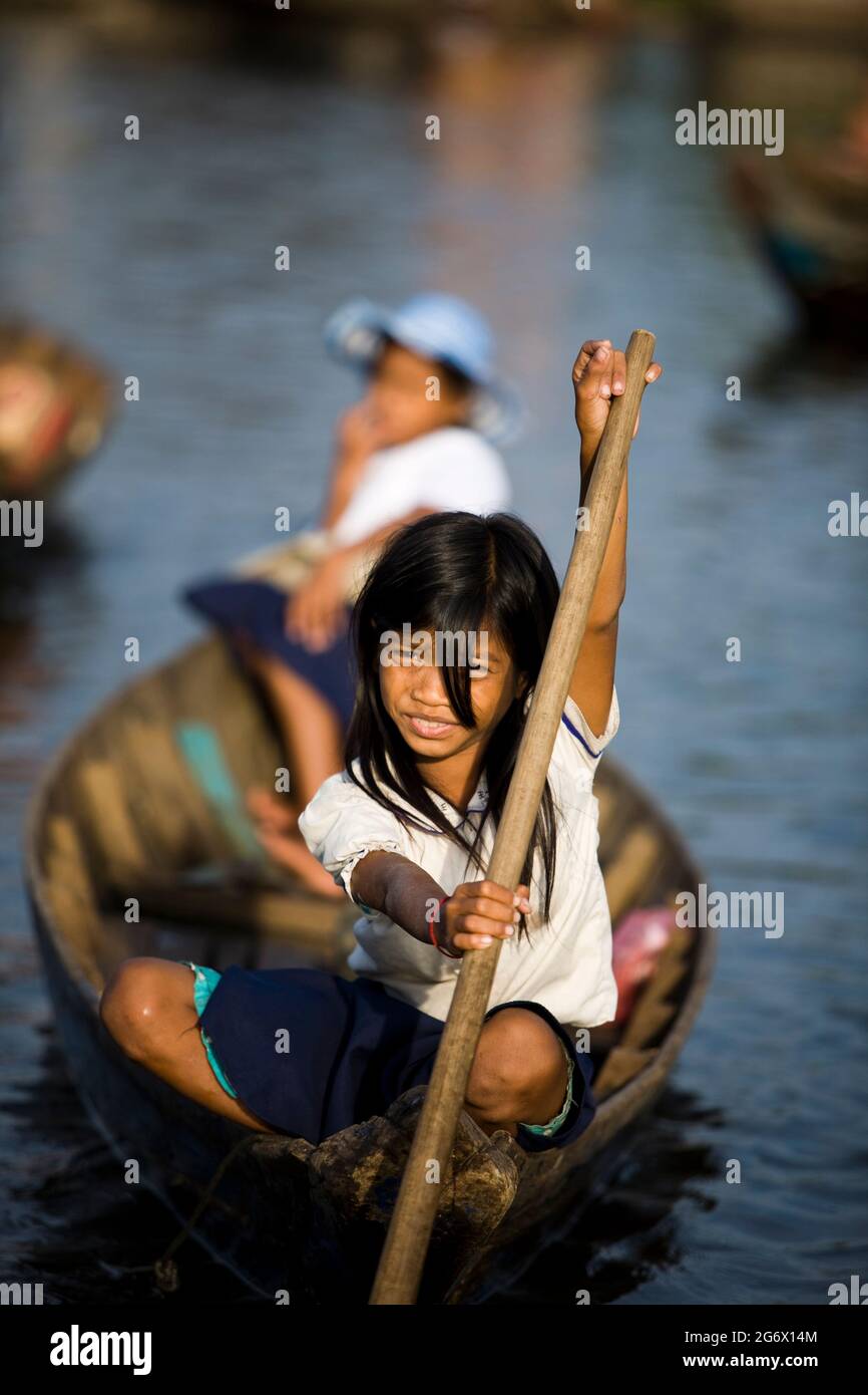 Asian girl rowing wooden boat to school. Life on the Tonle Sap ...