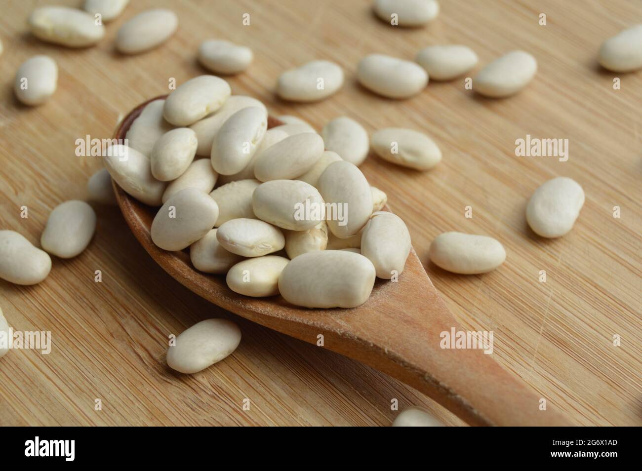 Organic healthy dried beans in wooden spoon on bamboo cutting board ...