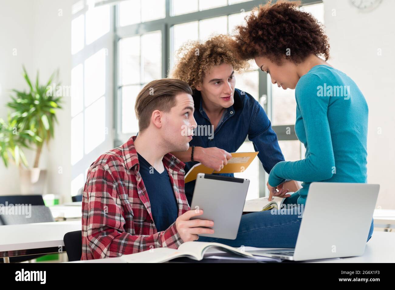 Three involved students sharing ideas and opinions about different ...