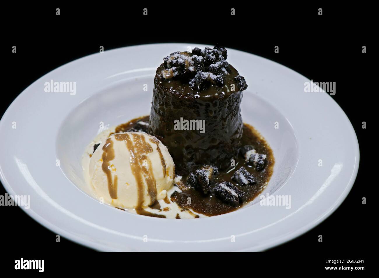 sticky toffee pudding with vanilla ice cream and caramel sauce in a ...
