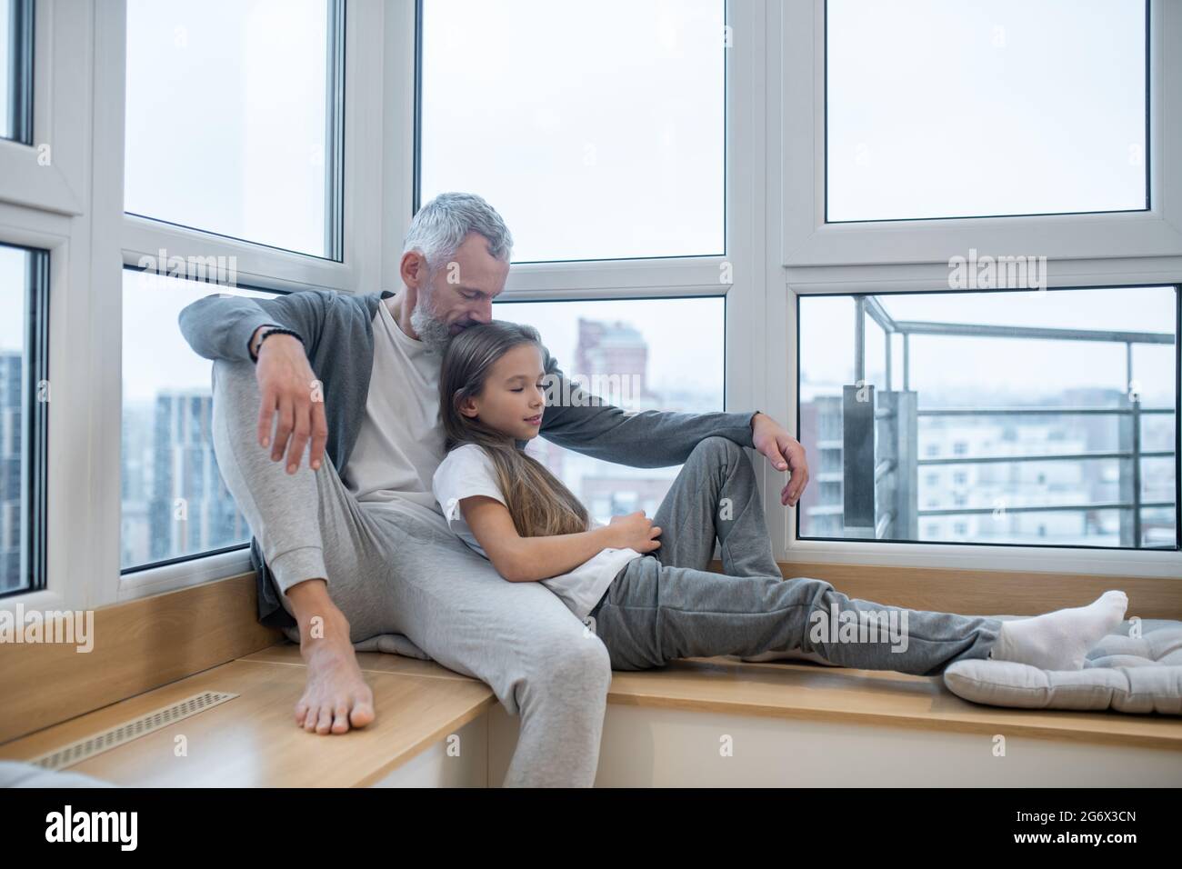 A dad sitting at the window with his daughter Stock Photo - Alamy