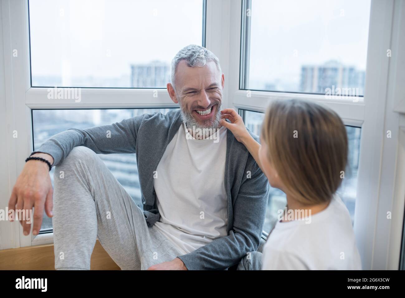 A dad sitting at the window with his daughter Stock Photo - Alamy