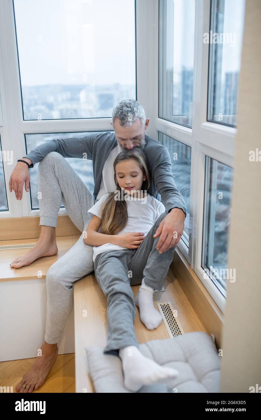 A dad sitting at the window with his daughter Stock Photo - Alamy
