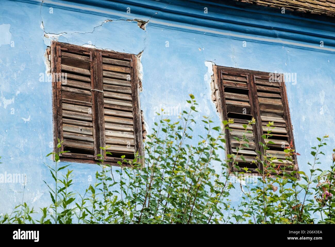 old painted adobe house facade with wooden shutters in Transylvania ...