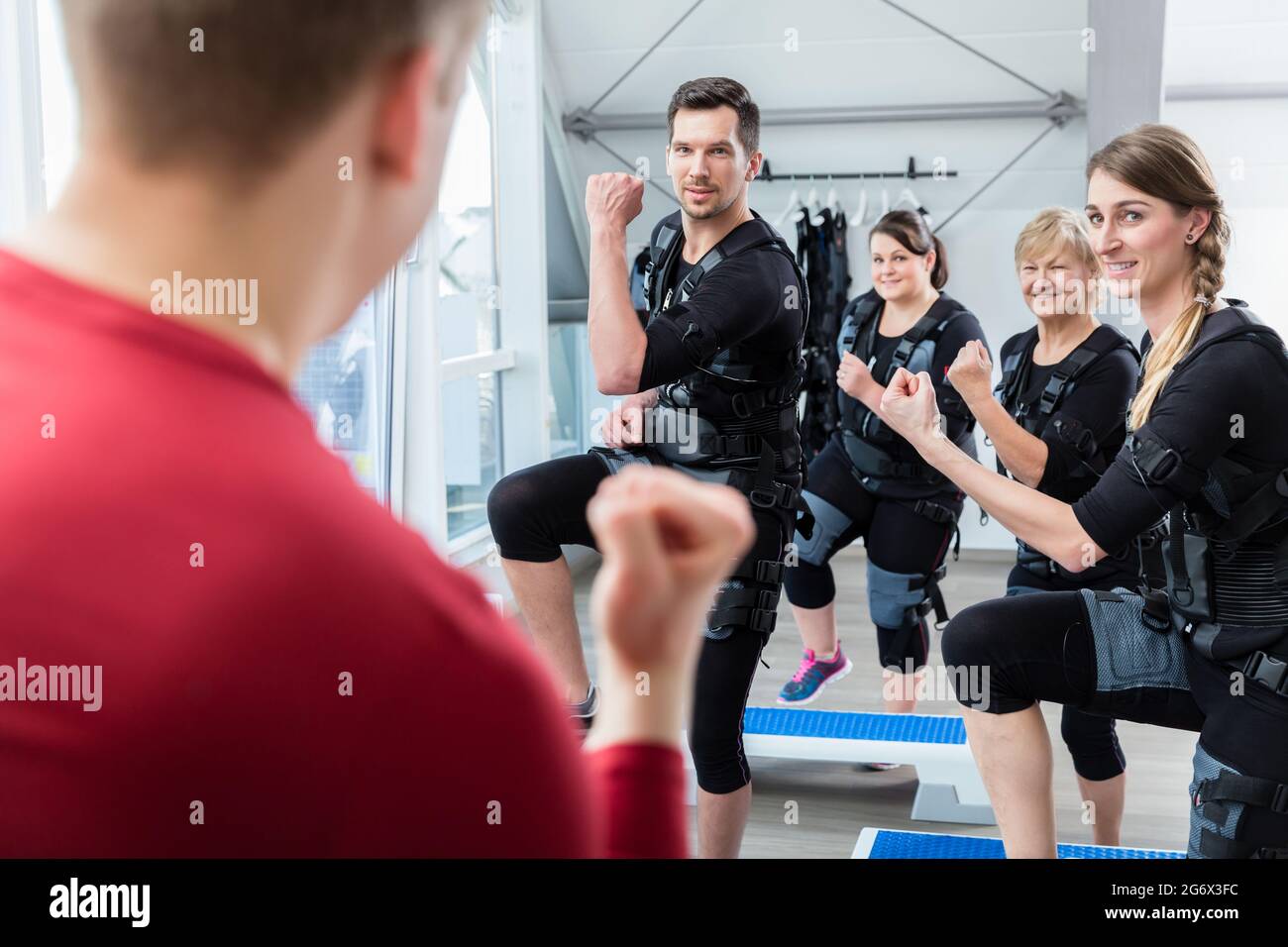 Group of people having ems training in the electro gym doing core ...