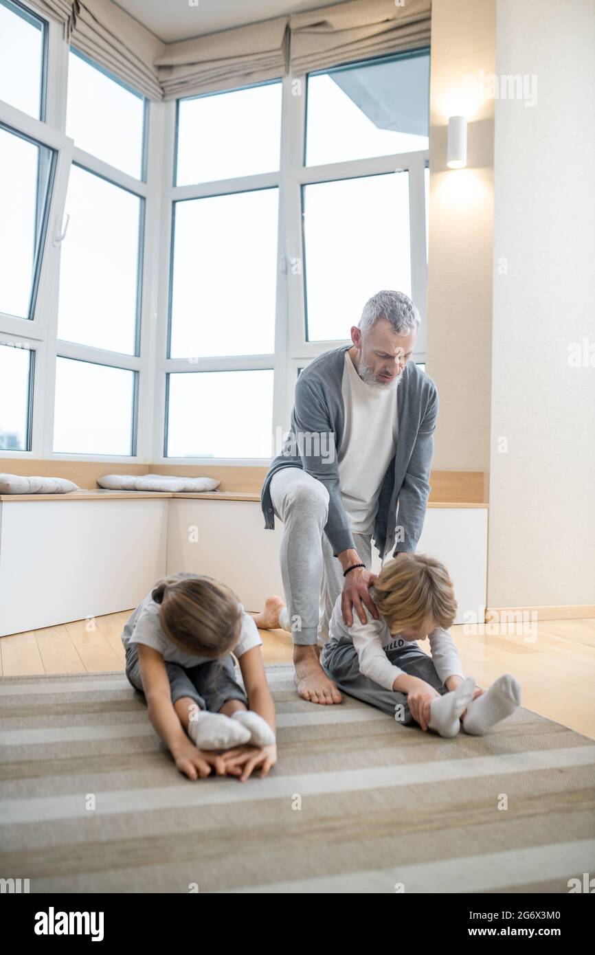 Father training his kids at home making them stretch correctly Stock ...