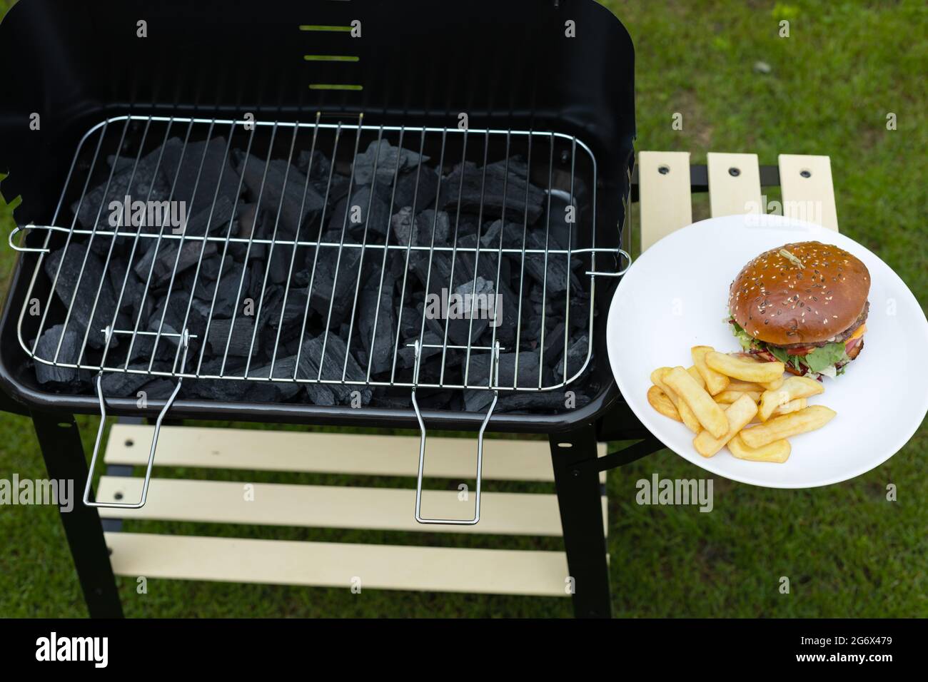 Homemade tasty cheeseburger being cooked on a on backyard barbecue ...