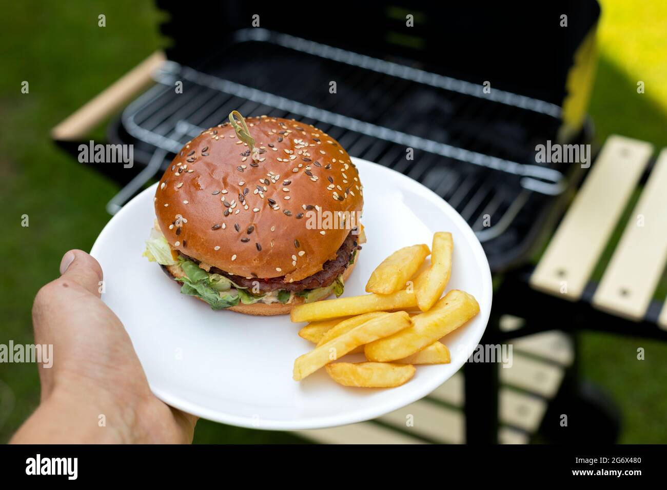 Homemade tasty cheeseburger being cooked on a on backyard barbecue ...