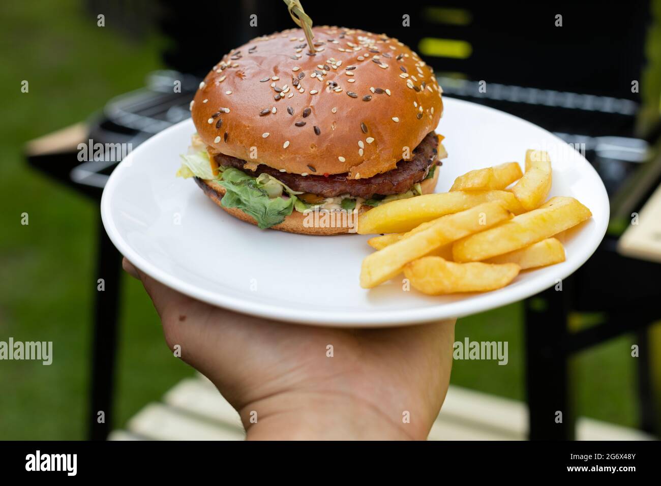 Homemade tasty cheeseburger being cooked on a on backyard barbecue ...