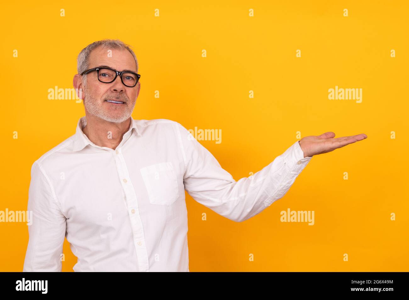 senior adult man pointing open hand at space Stock Photo - Alamy