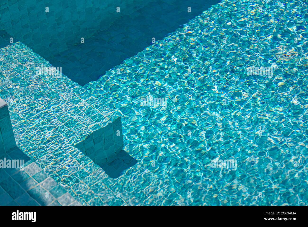 Wavy water surface of swimming pool with stairs and pool edges. Sunny ...