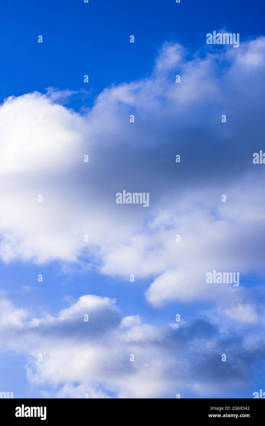 Shiny blue sky with white clouds vertical view Stock Photo - Alamy