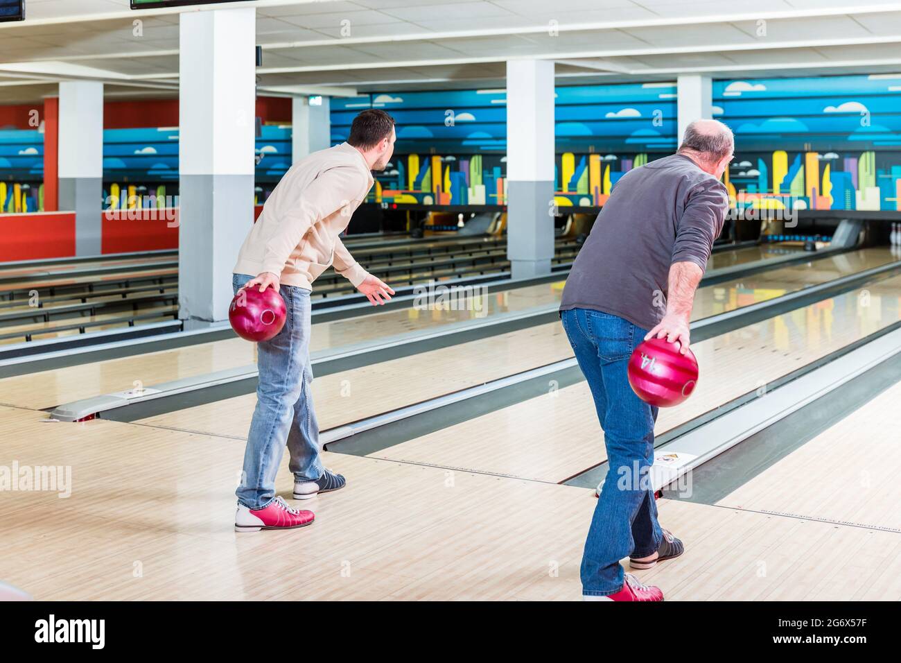 Rear view of father and son playing bowling game Stock Photo - Alamy