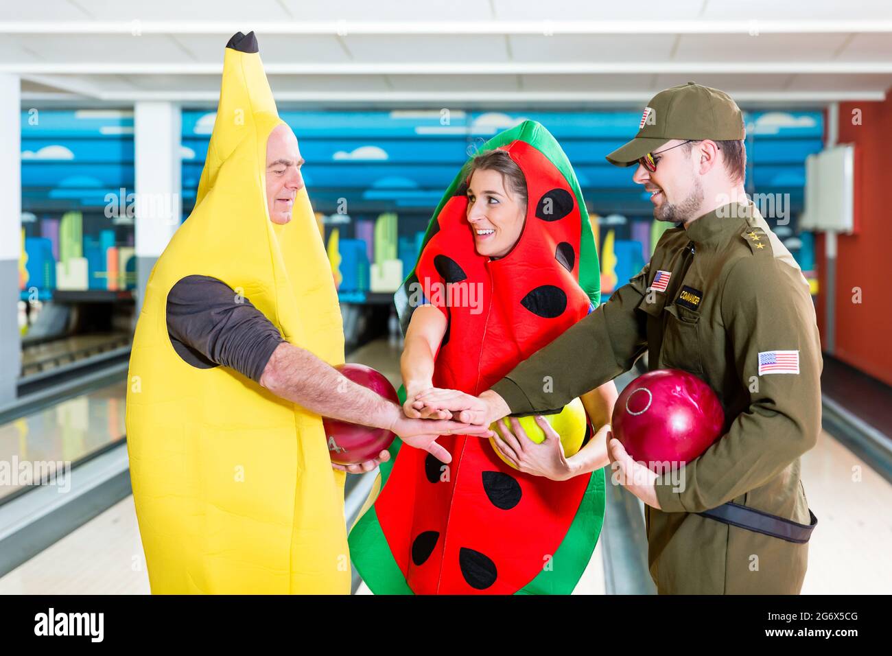 Happy family in fancy clothing gathering their hands before bowling ...