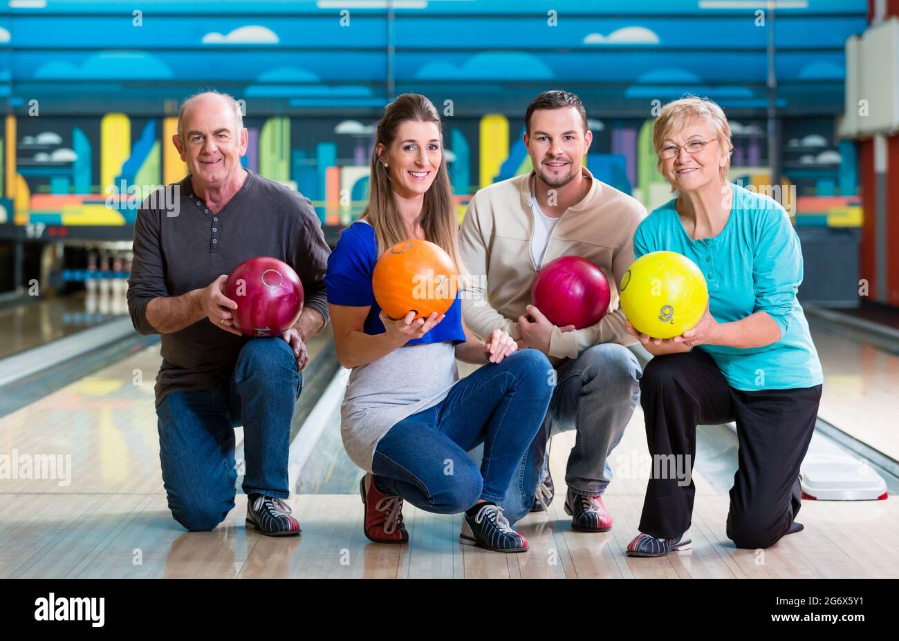 Happy family with multi colored bowling ball posing in alley Stock ...