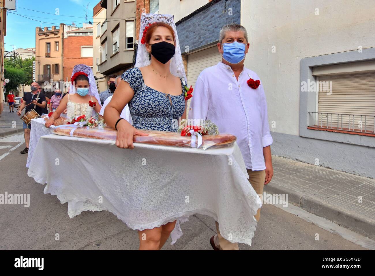 A father and daughter carry the blessed bread as they parade, during ...