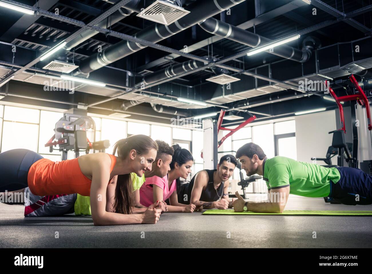 Fit trainer giving training at fitness center Stock Photo - Alamy