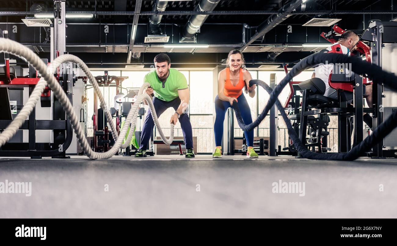 Healthy people training with rope at fitness gym Stock Photo - Alamy